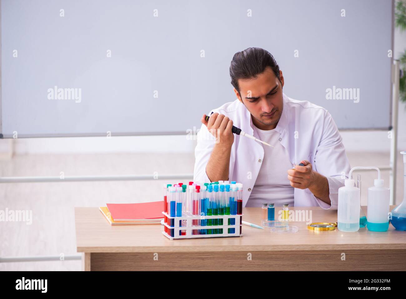 Young chemistry teacher in the classroom Stock Photo - Alamy