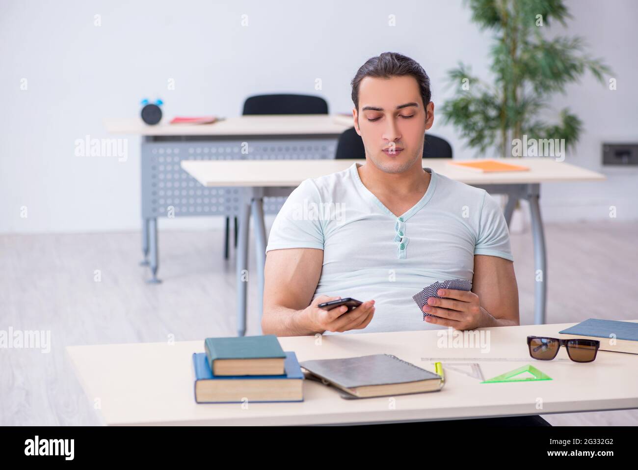 Male student playing cards during exam preparation in the classroom ...