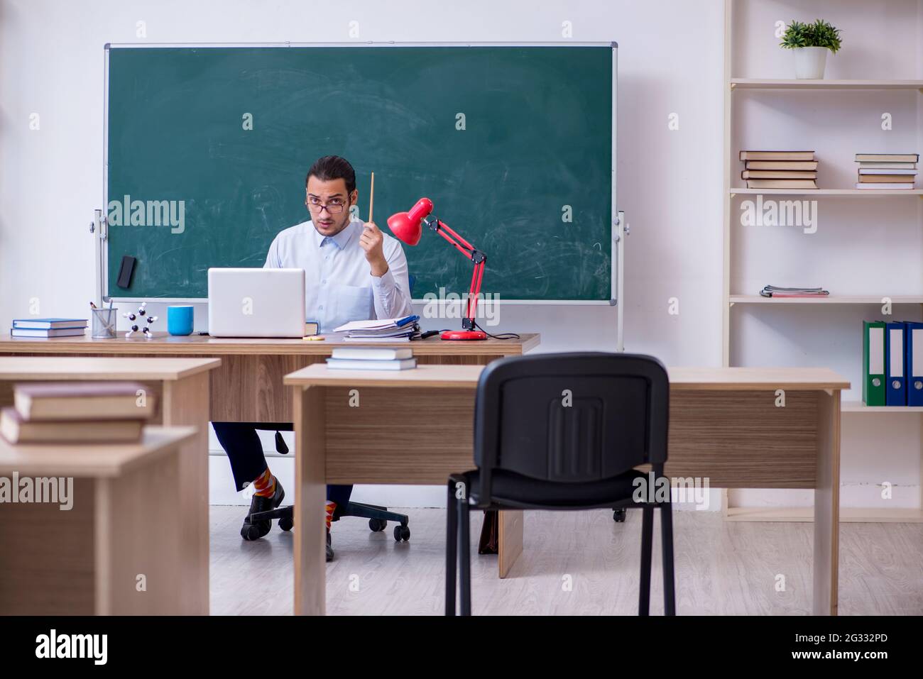 Young teacher in front of green board Stock Photo - Alamy
