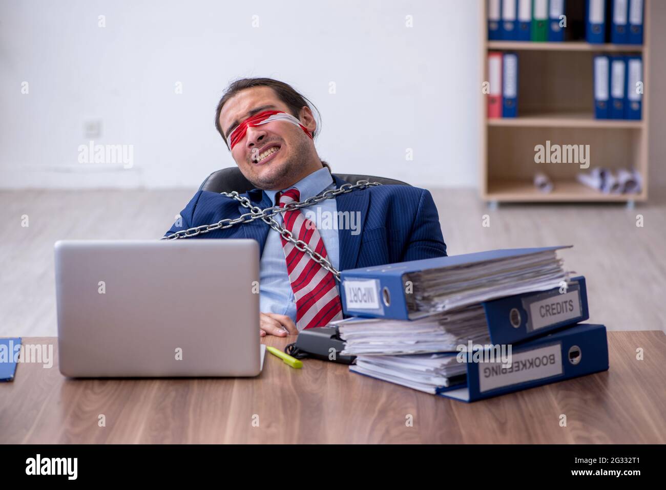 Chained employee unhappy with excessive work in the office Stock Photo ...