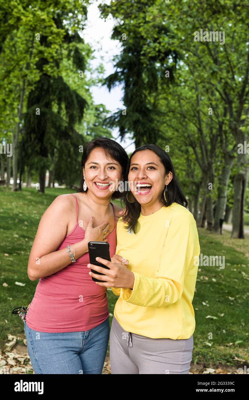 Young latin female in a video call with a smartphone with friends cause ...