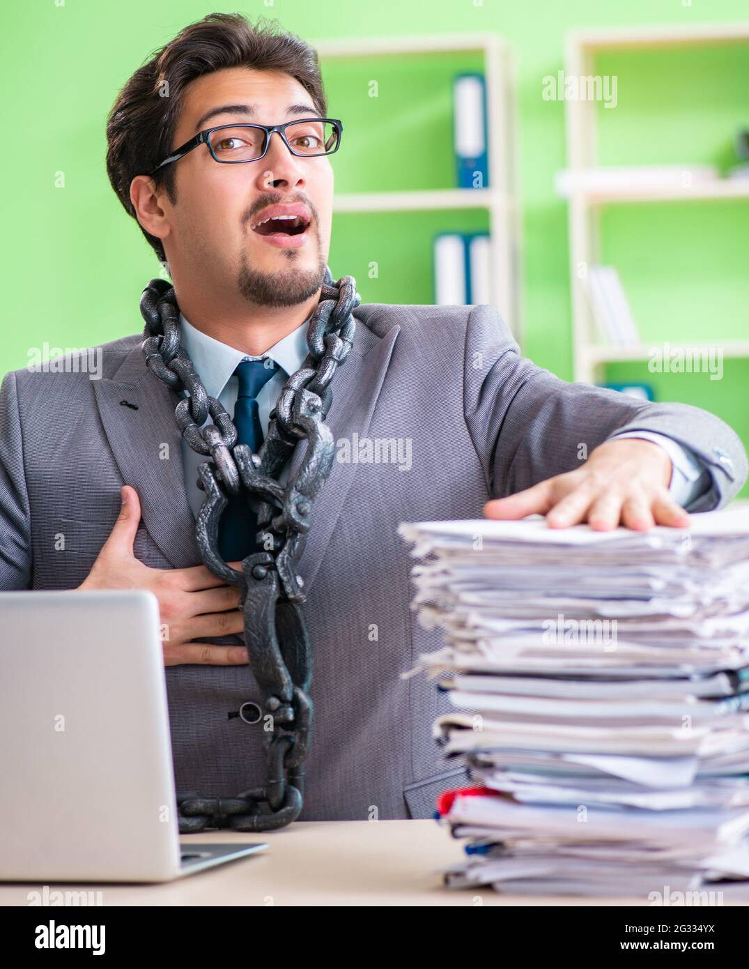 The employee chained to his desk due to workload Stock Photo - Alamy