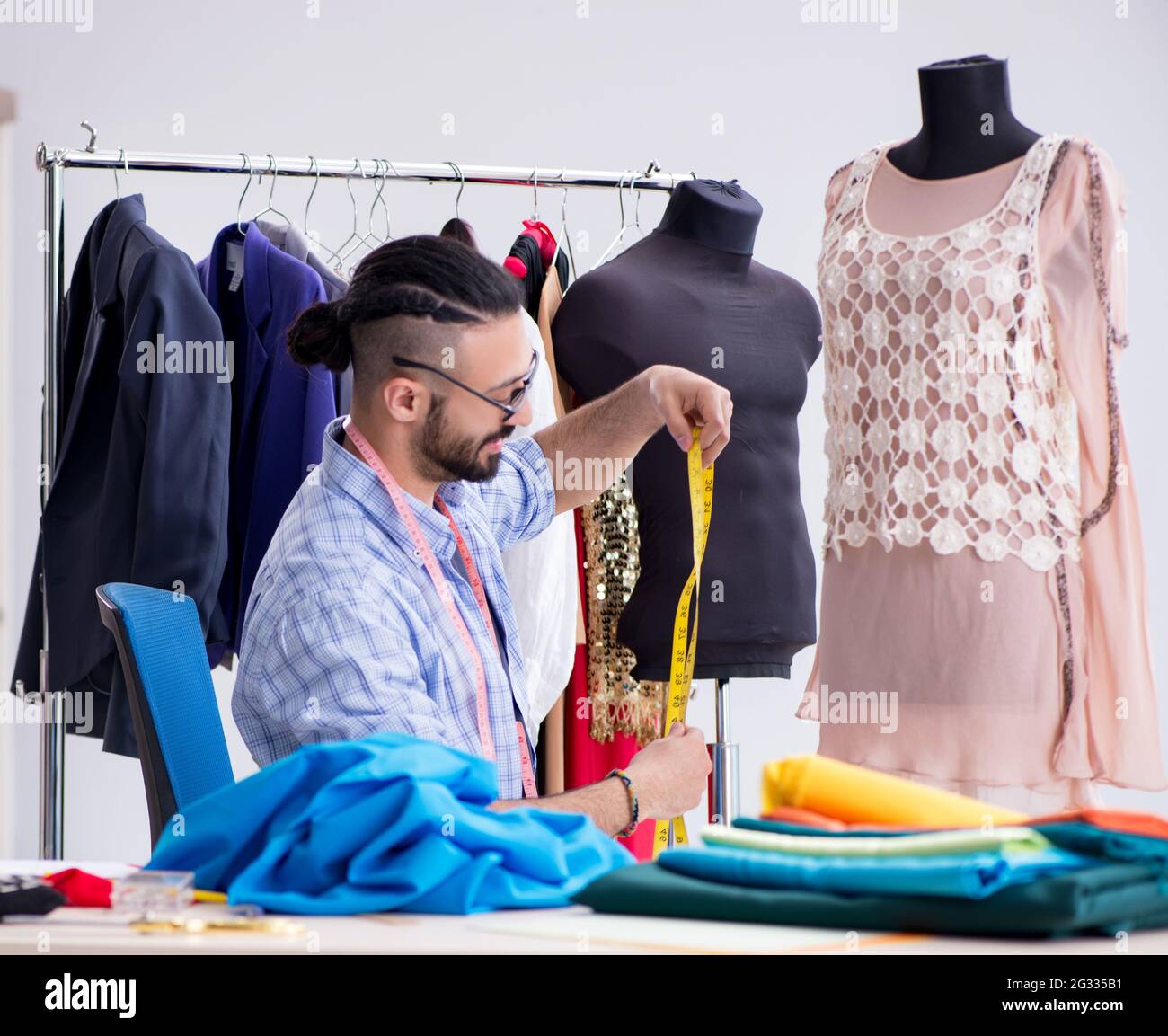 The male tailor working in the workshop on new designs Stock Photo - Alamy