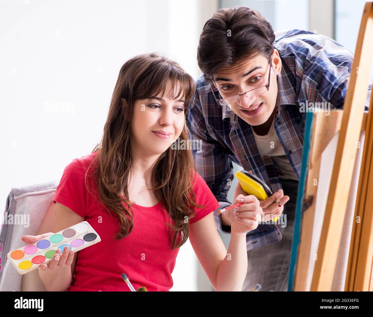 The artist coaching student in painting class in studio Stock Photo - Alamy