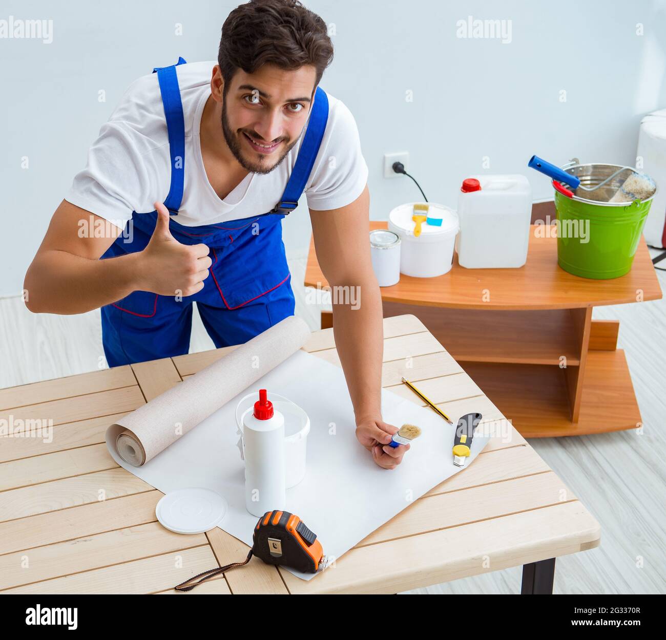 The worker working on wallpaper during refurbishment Stock Photo - Alamy