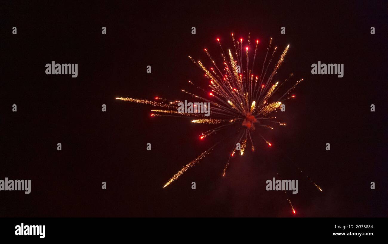 The beautiful red and orange fireworks in the dark sky Stock Photo - Alamy
