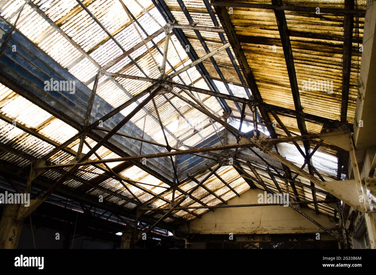 The weathered old and rusty metal structures of the ceiling of a ...