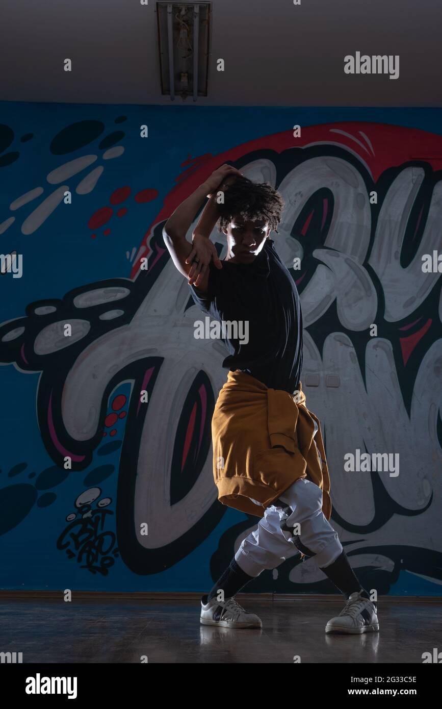 African American hip hop dancer (breakdancer) performing over graffiti ...