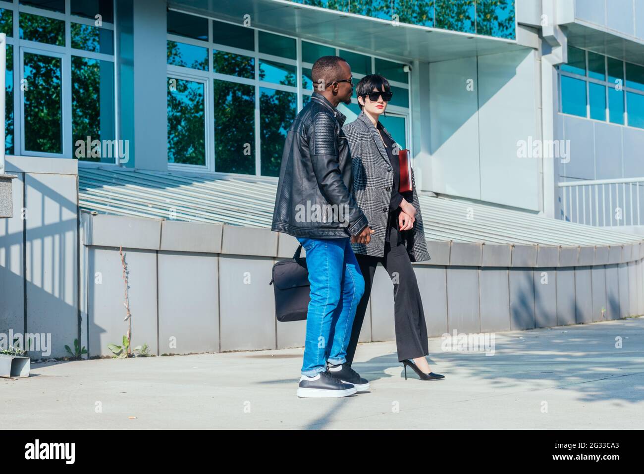 Rear view of formally dressed business colleagues walking towards their ...