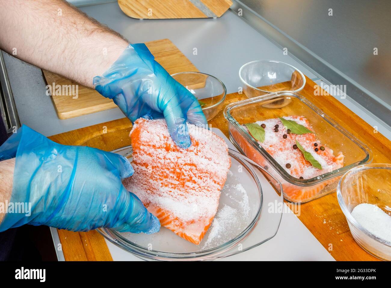 The process of making lightly salted salmon in the kitchen. Hands in ...