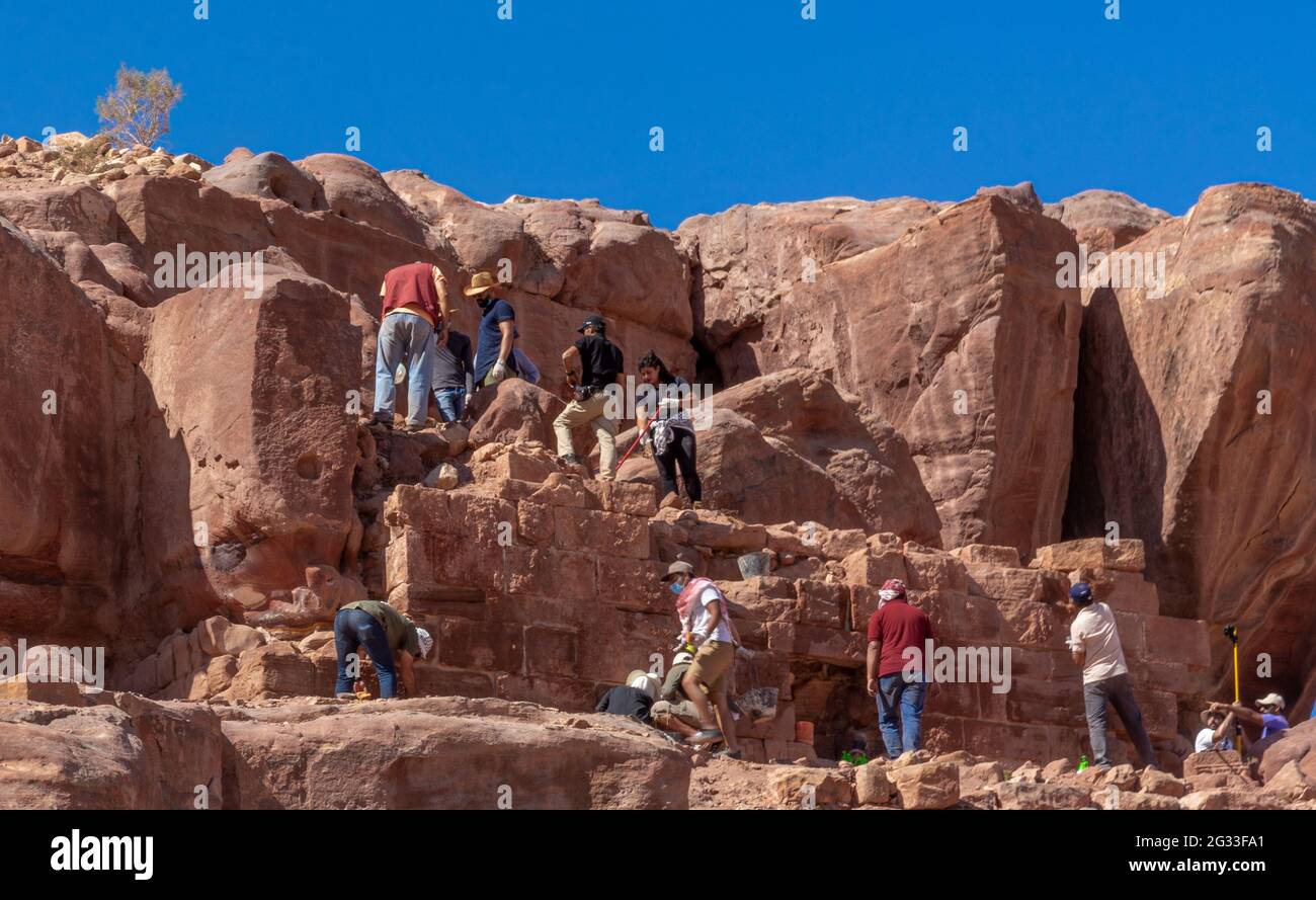 A group of workers doing reconstruction works at ruins of ancient city ...