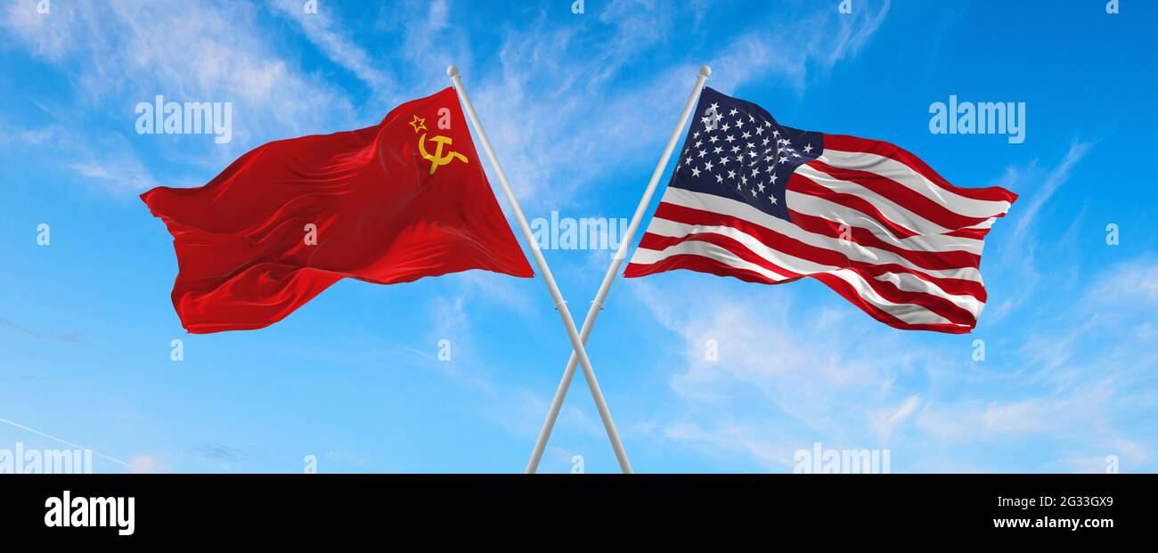 flags of USA and ussr waving in the wind on flagpoles against the sky with clouds on sunny day ...