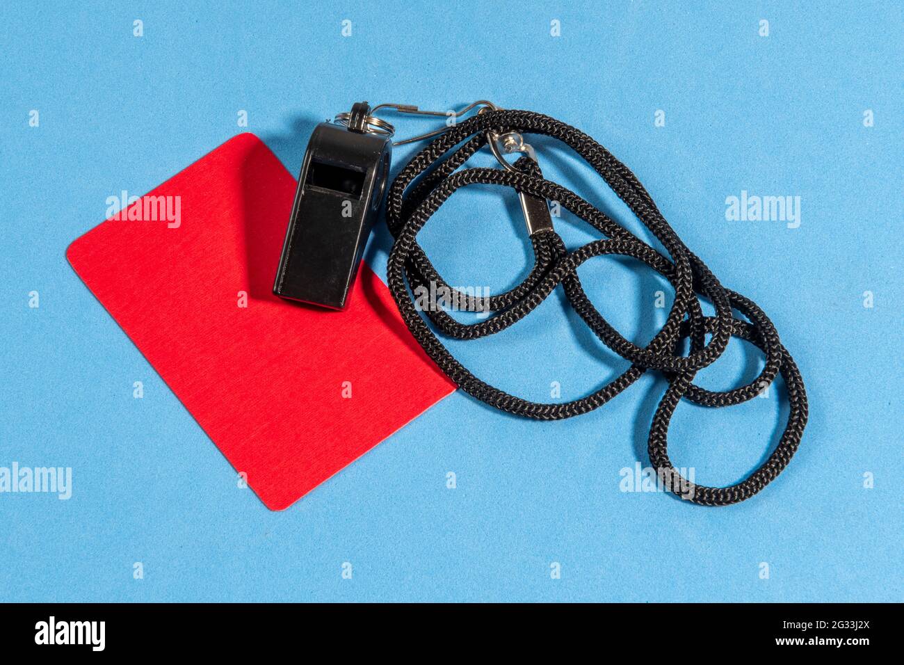 Red card and referee whistle with space for text in a blue background ...