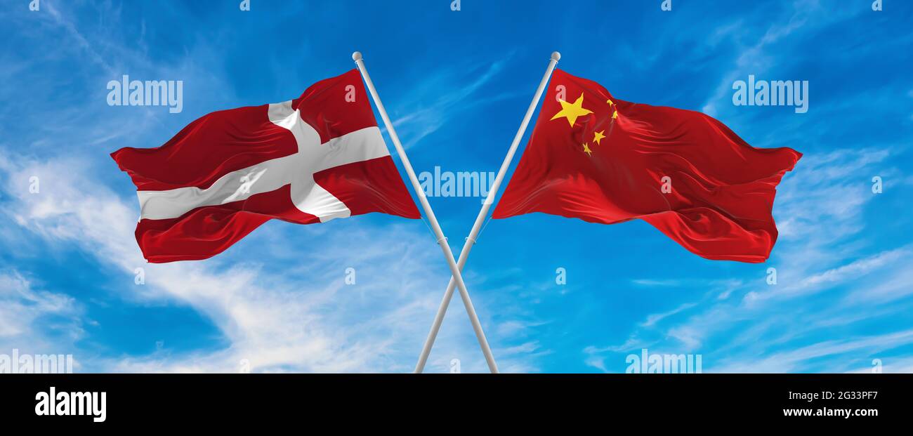 flags of China and denmark waving in the wind on flagpoles against sky ...