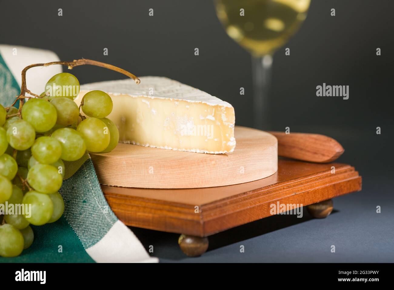 Smoked Baby Brie cheese with grapes, cloth napkin and glass of ...