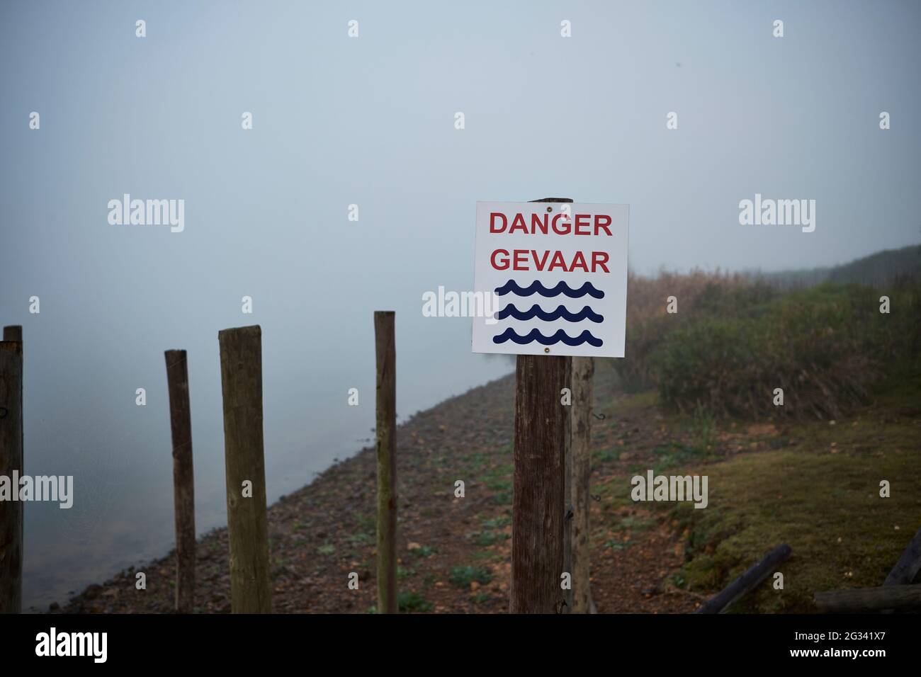 Warning sign near a lake on a misty morning Stock Photo - Alamy