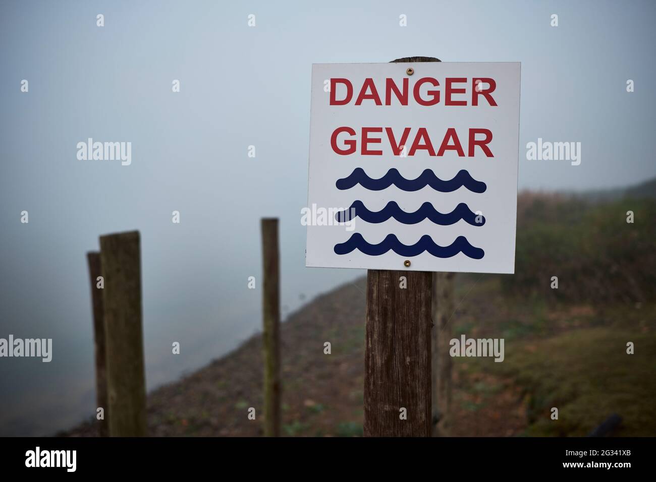 Warning sign near a lake on a misty morning Stock Photo - Alamy