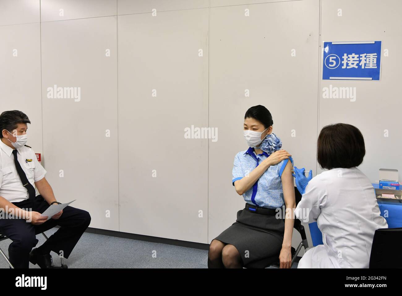 An ANA flight attendant Mika ABE (center) receives a Vaccination in the ...