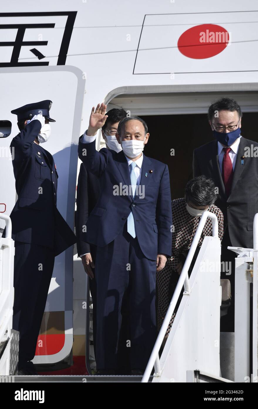 Japanese Prime Minister Yoshihide Suga (C) waves alongside his wife ...