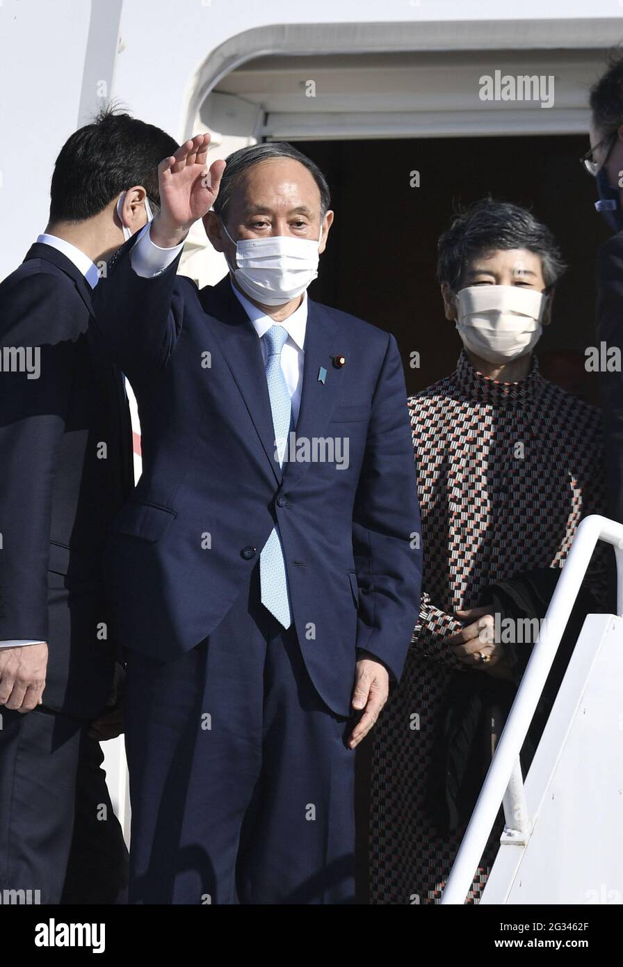 Japanese Prime Minister Yoshihide Suga (C) waves alongside his wife ...