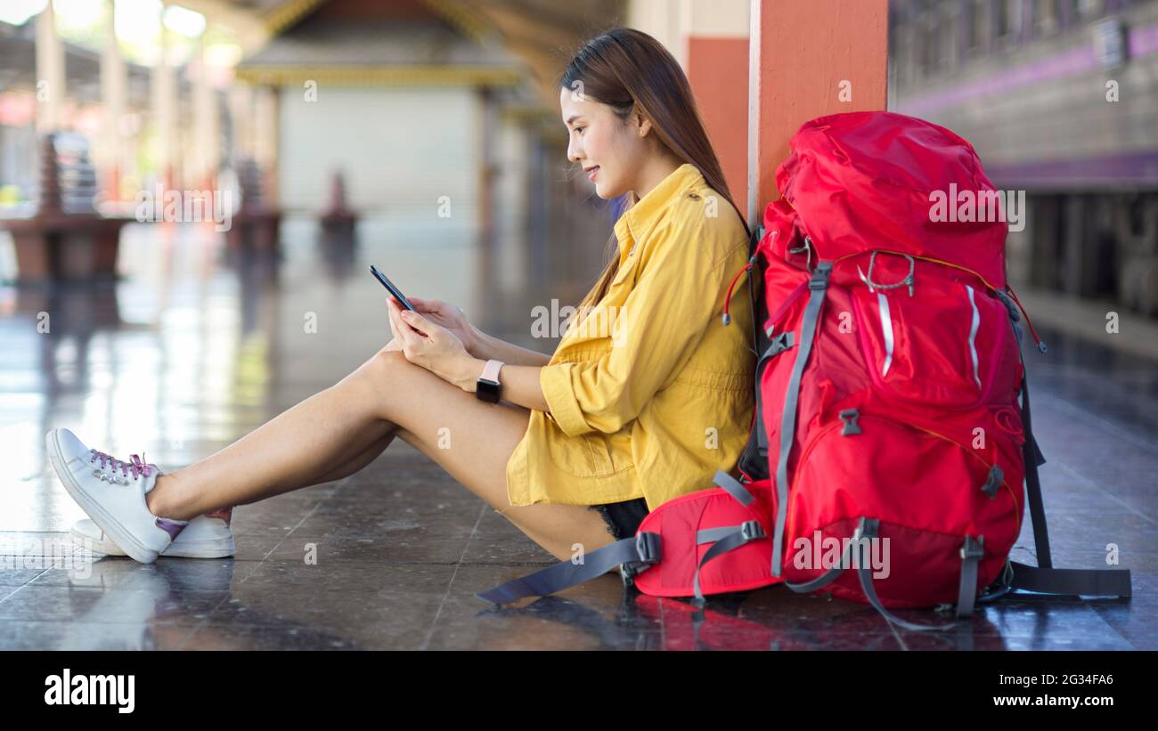 Side view of female traveller using digital tablet while sitting on the ...