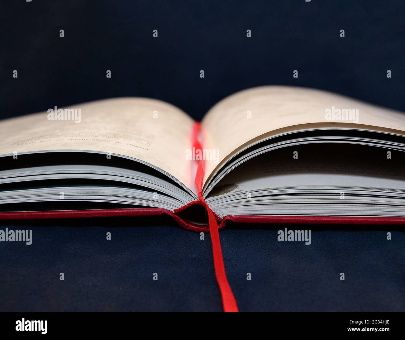 Closeup of an opened hardcover book on the black surface Stock Photo ...
