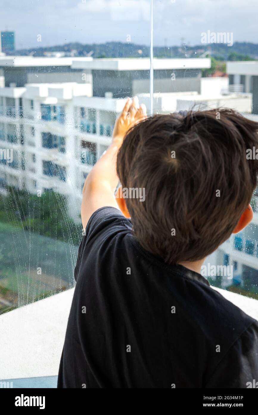 The concept of home apartment cleaning. A boy on the window and wipes ...