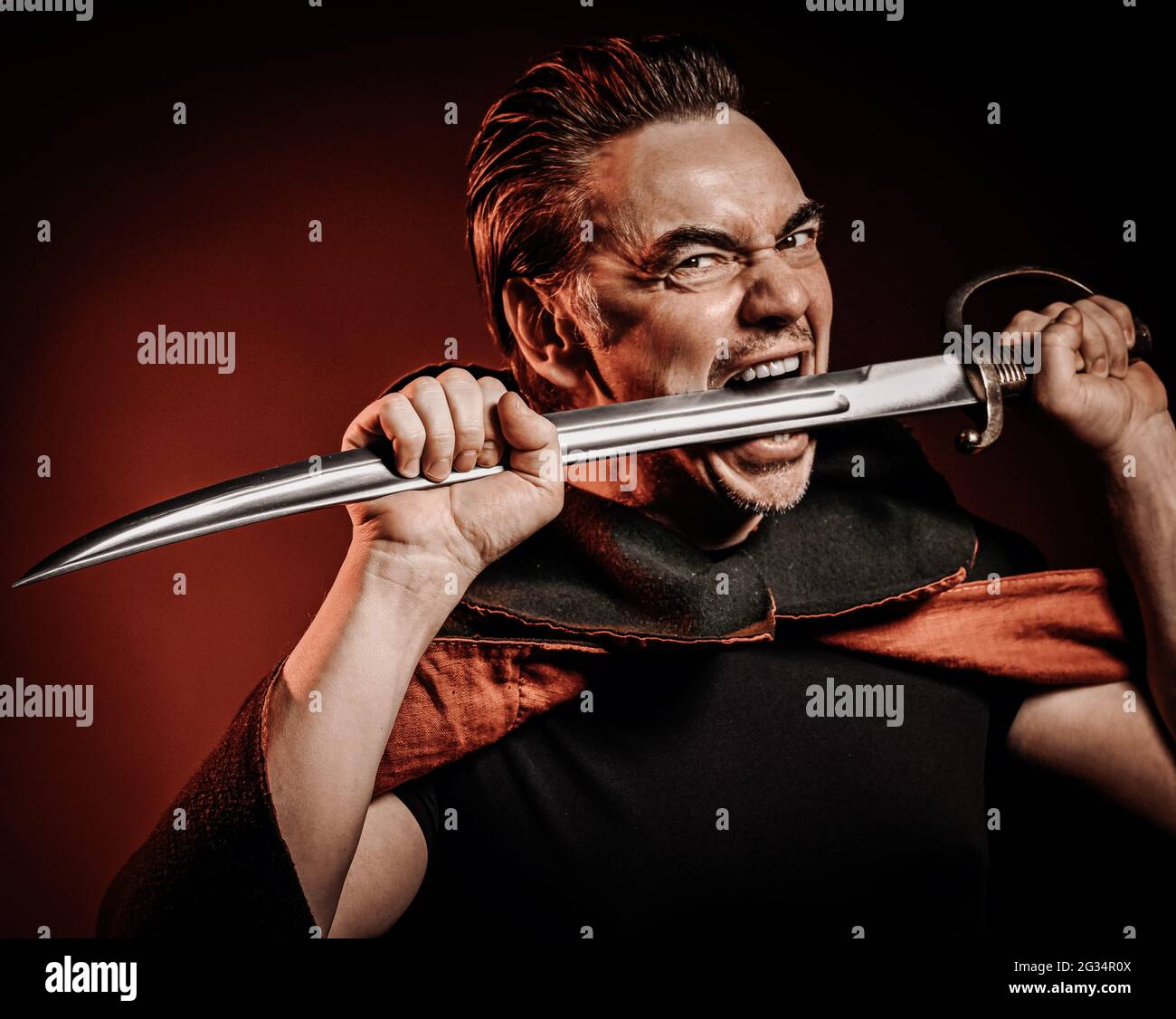 Portrait of strong courage fervor man warrior in cape holding sabre ...