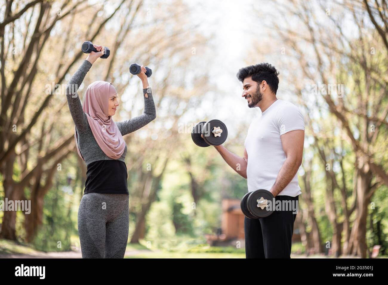 Side view of healthy muslim couple in sportswear having outdoors ...