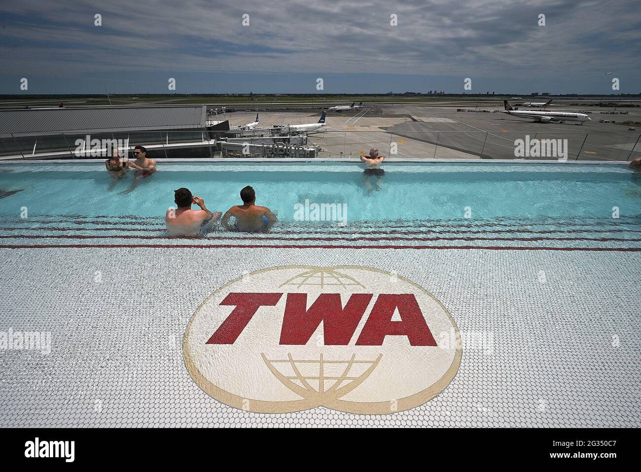 Visitors look out onto JFK International Airport runway 4 as they sit ...