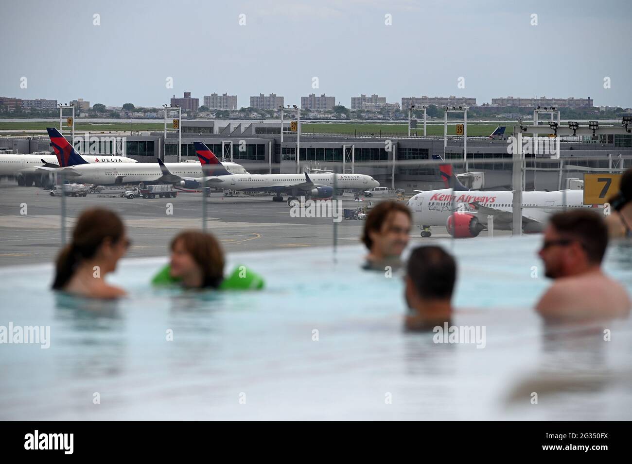 With parked aircraft in the background, people take a dip in the heated ...