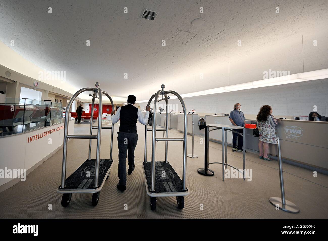 Front desk agent Ash Hussain pulls two luggage trolleys inside the TWA ...