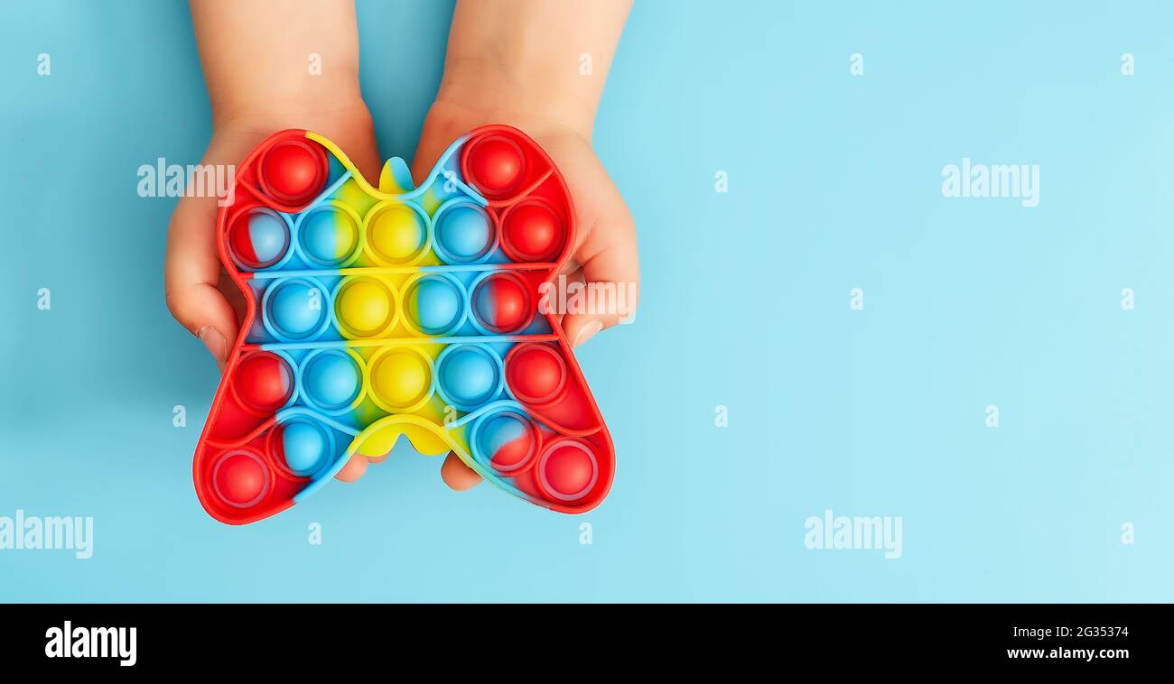 Trendy toy antistress. Anonymous child with colorful poppit game. Image ...