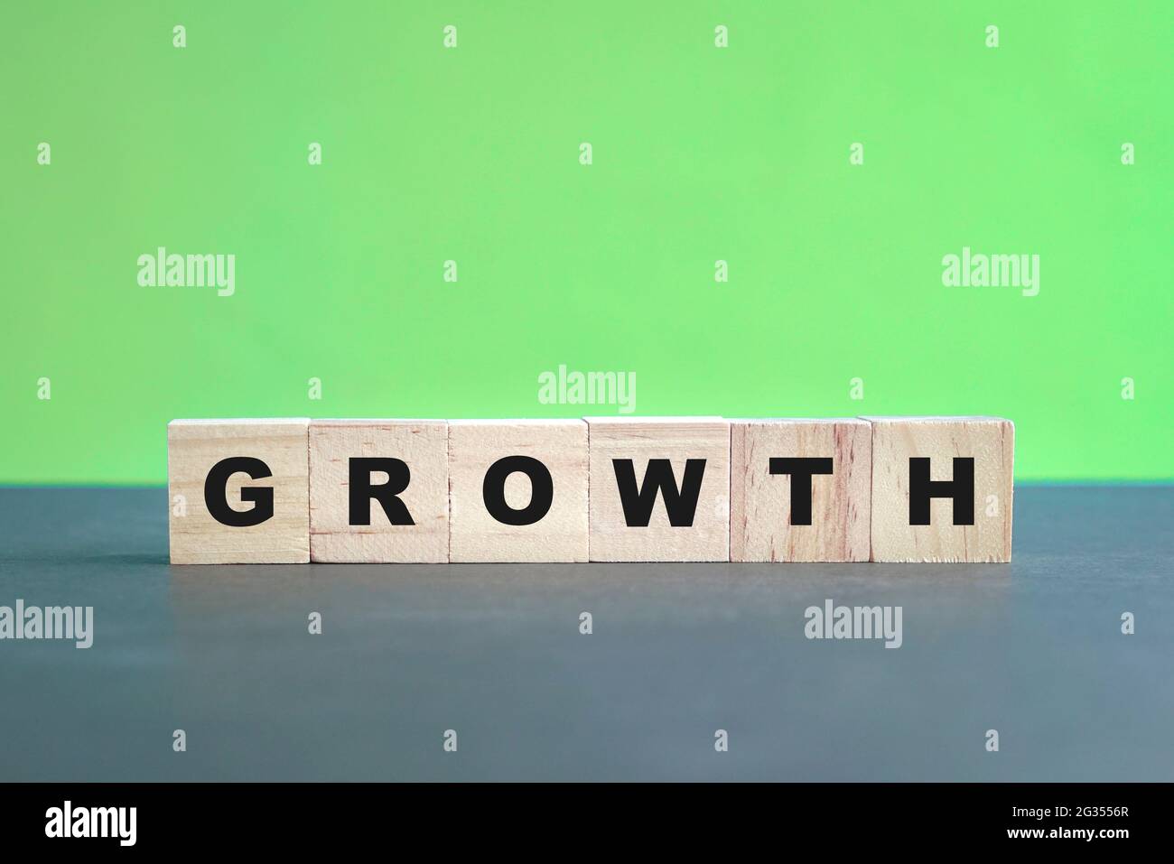 Growth text letters on wood cube with green background Stock Photo - Alamy
