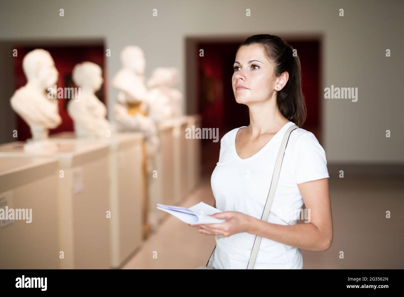 Woman observing sculptures exposition in art museum Stock Photo - Alamy