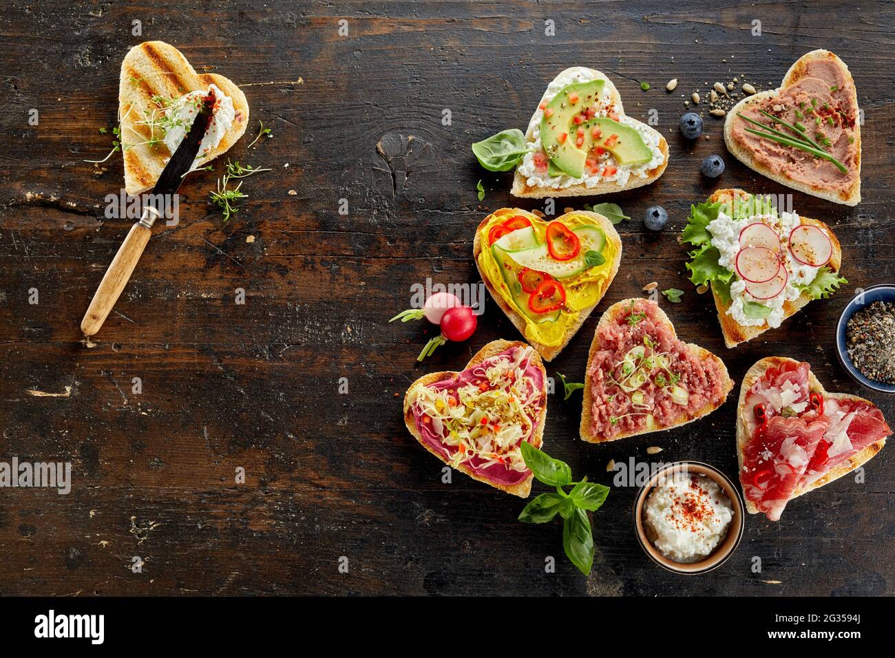From above of assorted toasts with delicious ingredients served on dark ...