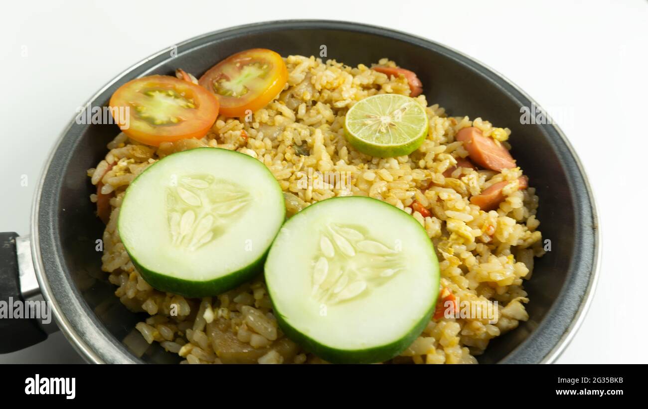 Fried rice served with fresh tomatoes and meatballs in a teflon bowl ...