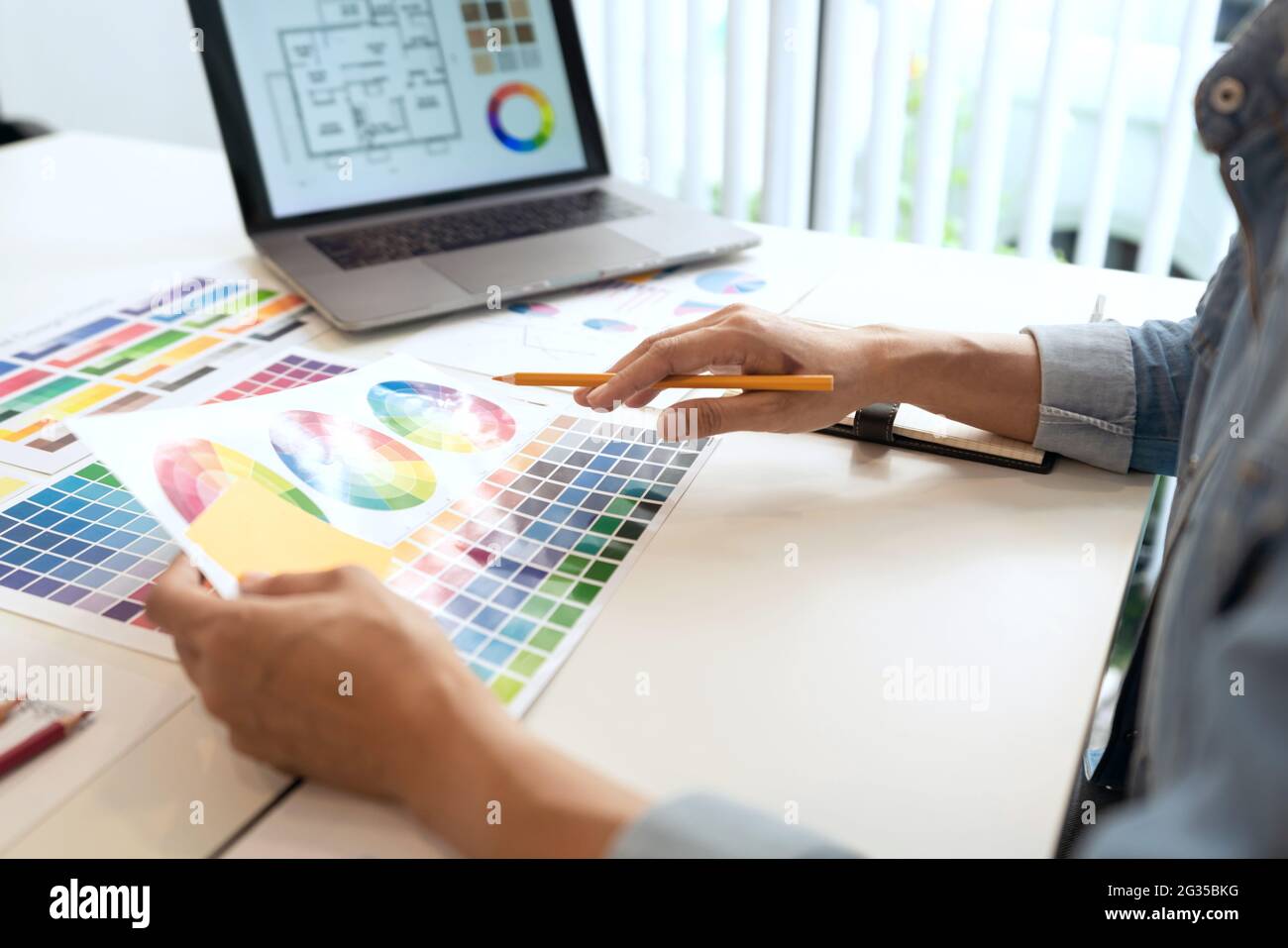 A female designer concentrating on selecting the color of customer’s ...