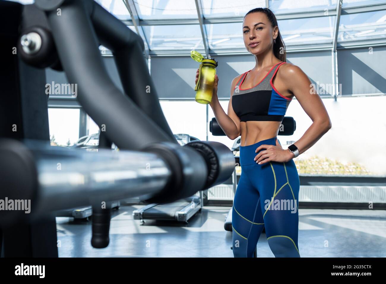 Girl drinking water from bottle during training at gym Stock Photo - Alamy