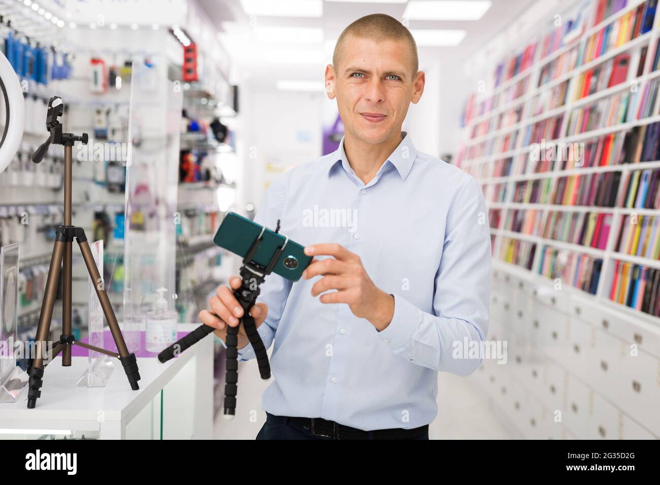 Male customer buying tripod at the multimedia store Stock Photo - Alamy