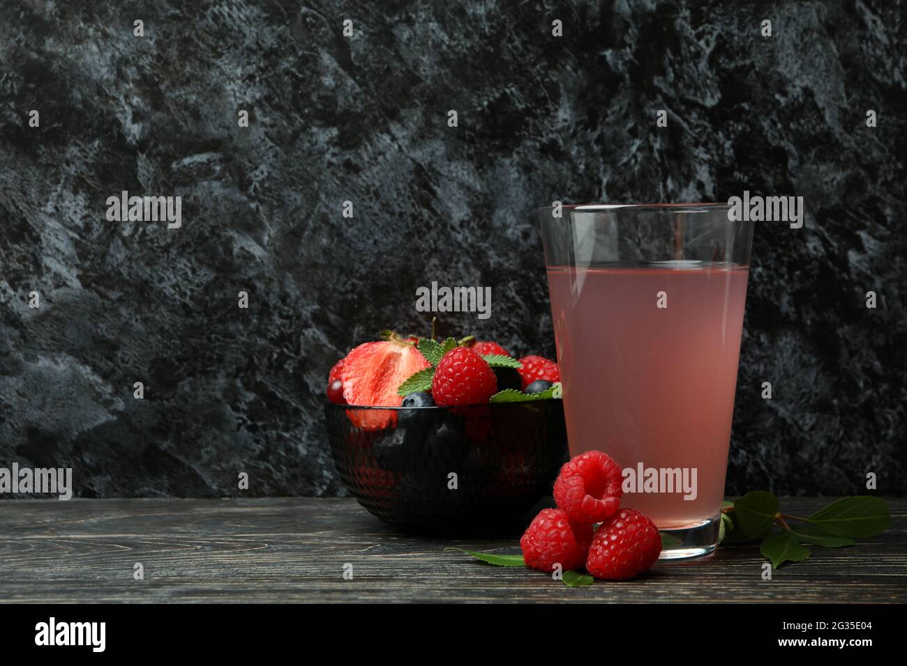 Bowl with berry mix and juice on wooden table Stock Photo - Alamy