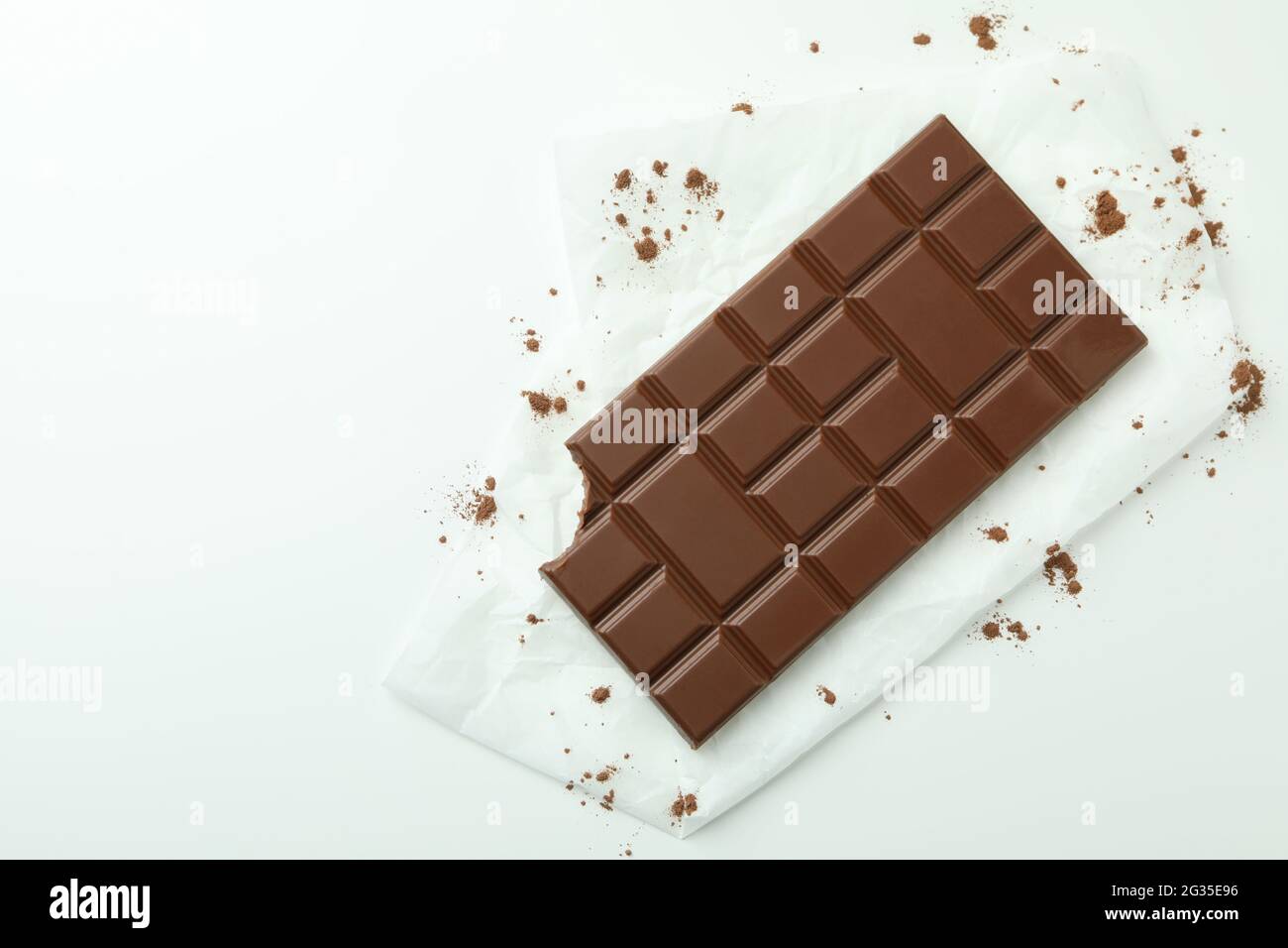 Tasty chocolate bar on paper on white background Stock Photo - Alamy