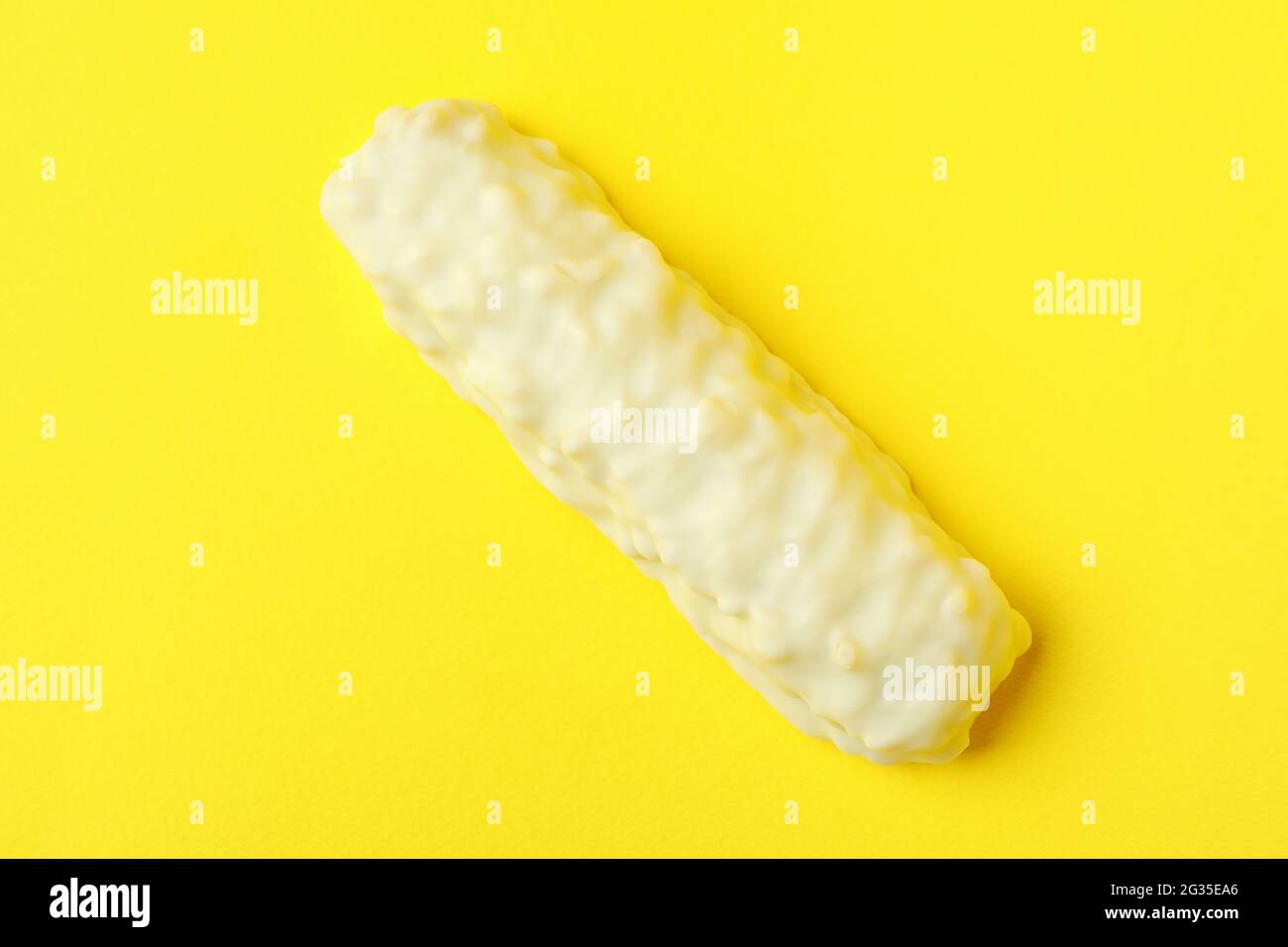 Tasty white candy bar on yellow background Stock Photo - Alamy