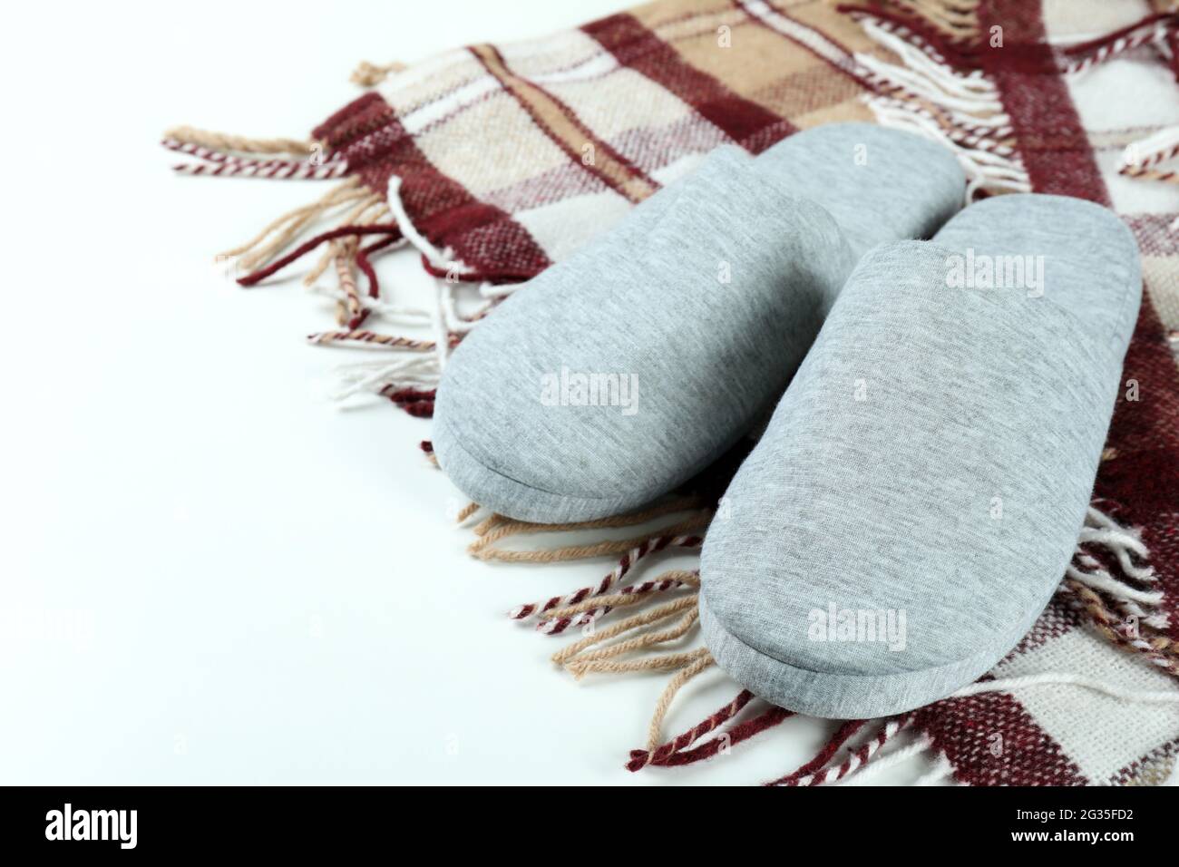 Pair of house slippers and plaid on white background Stock Photo - Alamy