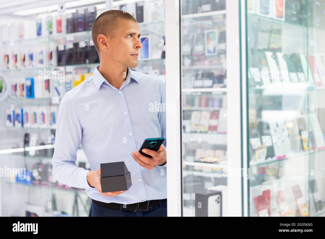Man chooses mobile phone in electronics store Stock Photo - Alamy