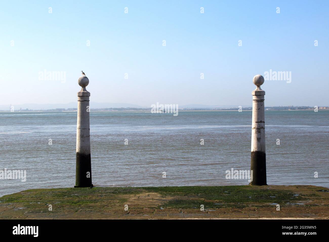 Scenic view of two pillars by the ocean in Lisbon, Portugal Stock Photo ...
