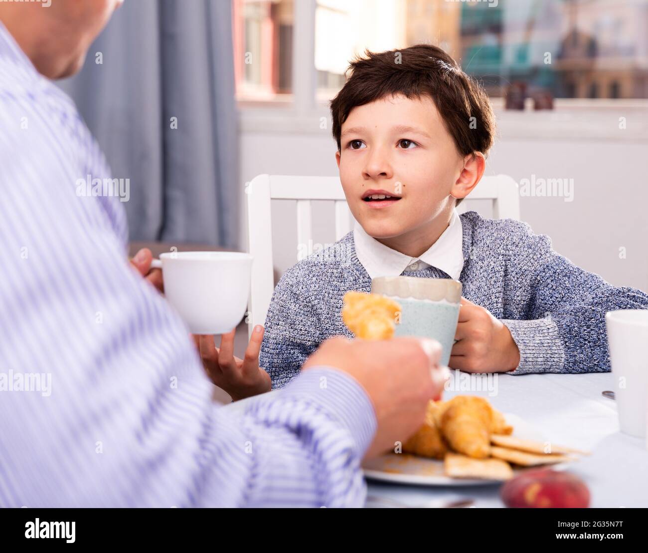 Cheerful boy talking to father Stock Photo - Alamy