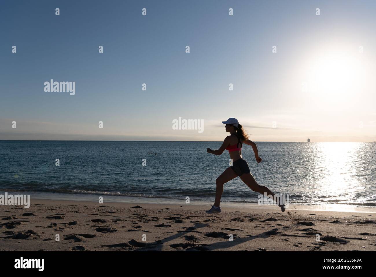 Running is my favorite. Fit girl run along seaside. Woman runner. Trail ...