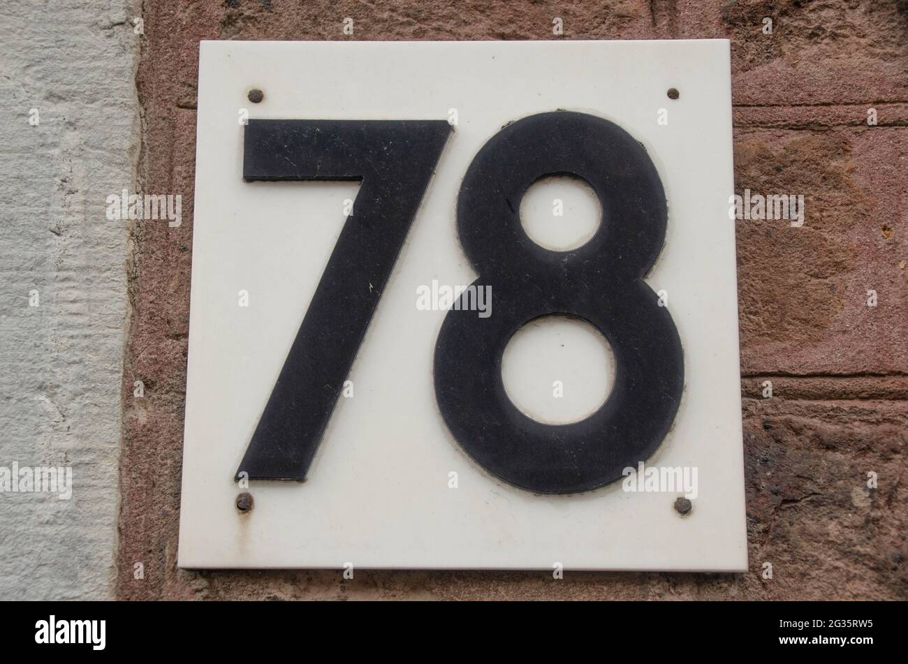 A sign on a wall with the number Stock Photo - Alamy