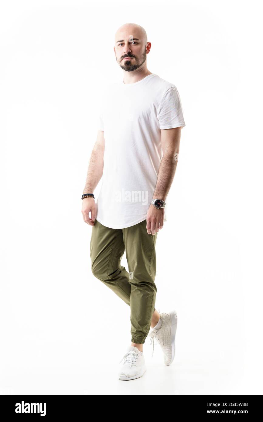 Shaved bald bearded young man in casual stylish clothes looking at ...